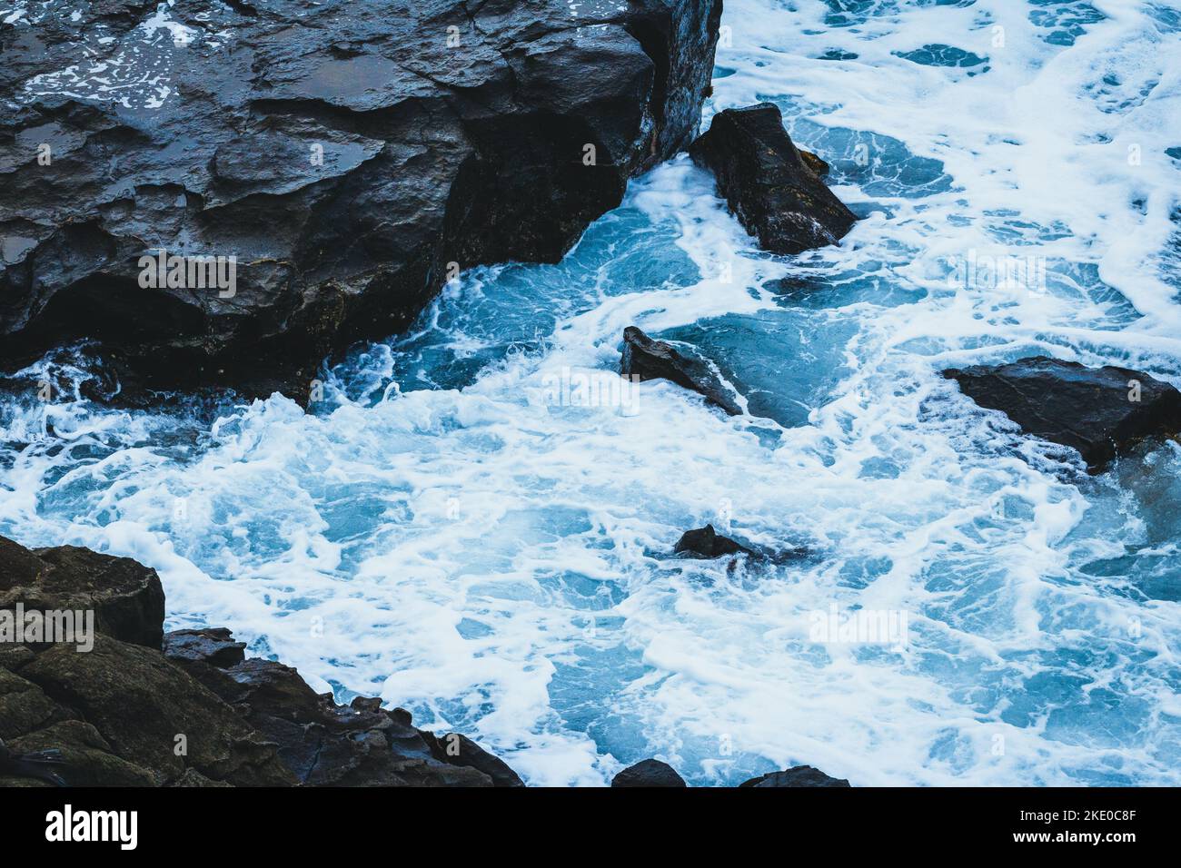 The view of bluish-white water surface and dark rocks. Katiki Point ...
