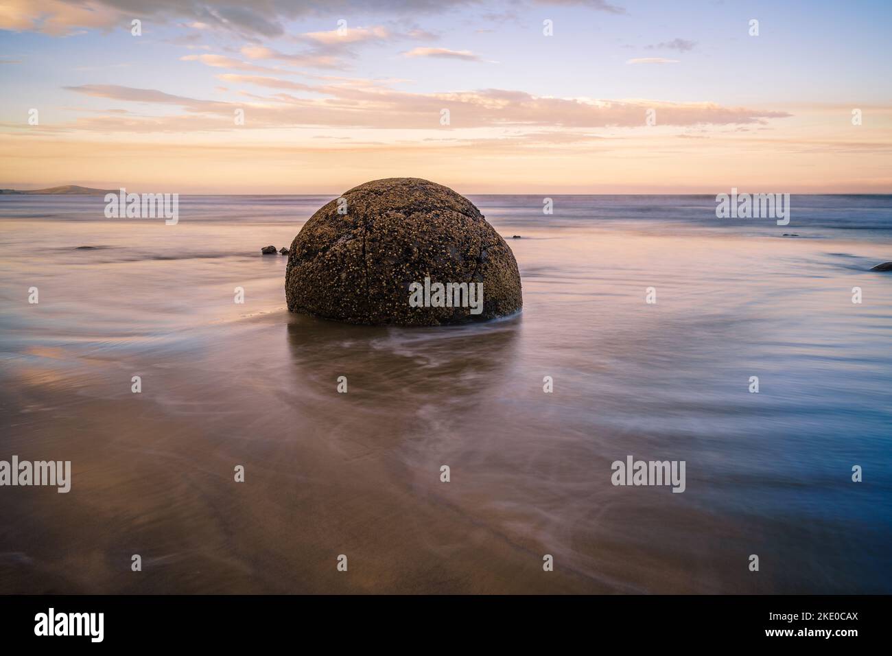 A round stone on the water's surface. Moeraki Boulders Beach, Hampden ...