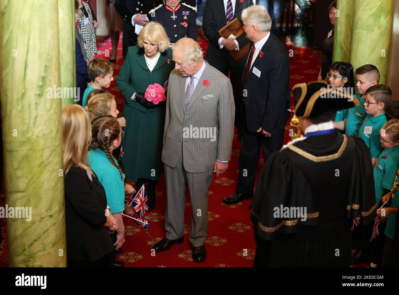 King Charles III and the Queen Consort speak to young children during a ...