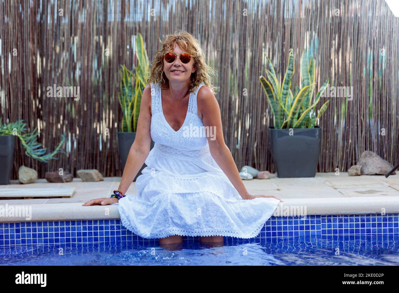 A gorgeous Hispanic woman in a white dress near the pool Stock Photo ...