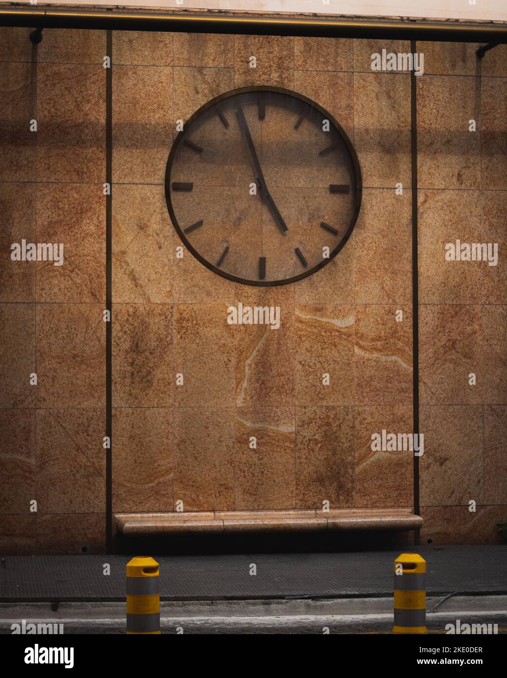 A vertical shot of a simple clock design on a marble brown wall Stock ...