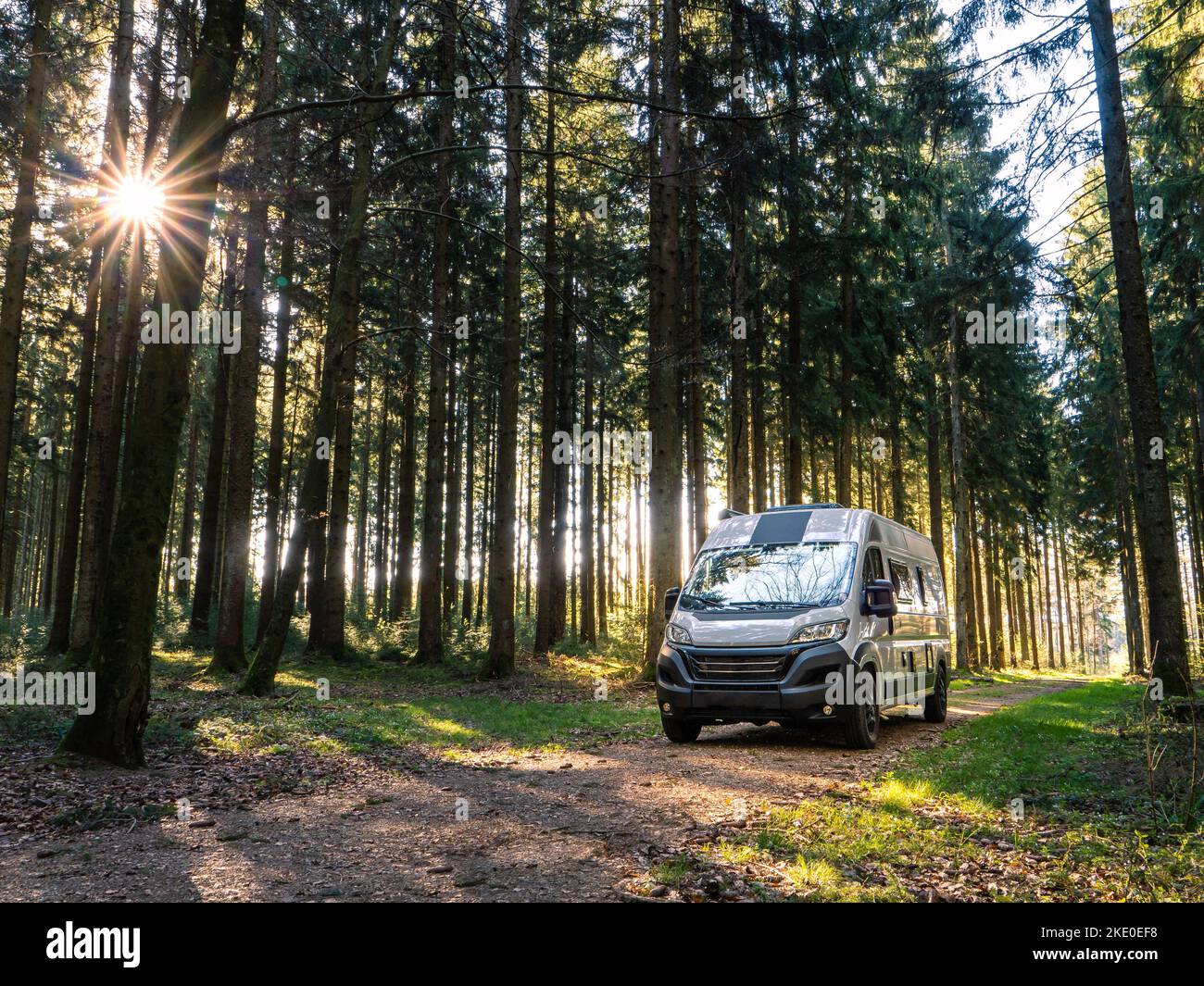 A campervan driving through the trees in the Black Forest Mountains in ...