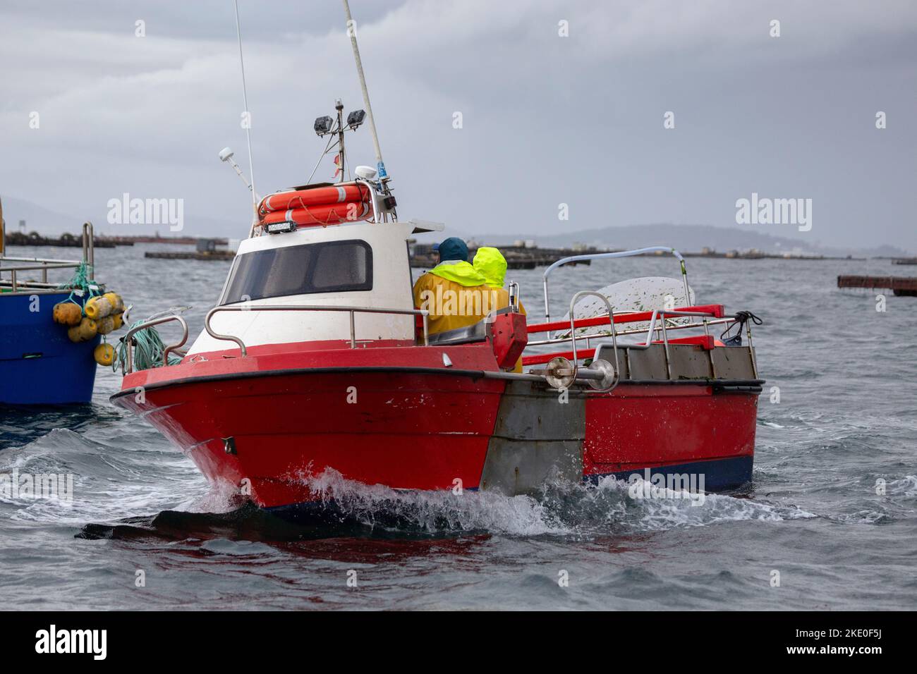 Inshore fishing sailors fish in their traditional wooden boat in the ...
