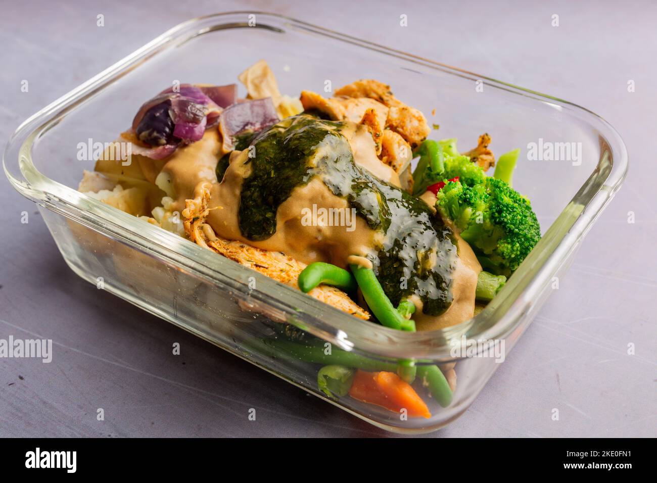 A colorful dish of chicken and vegetables served with green and white ...