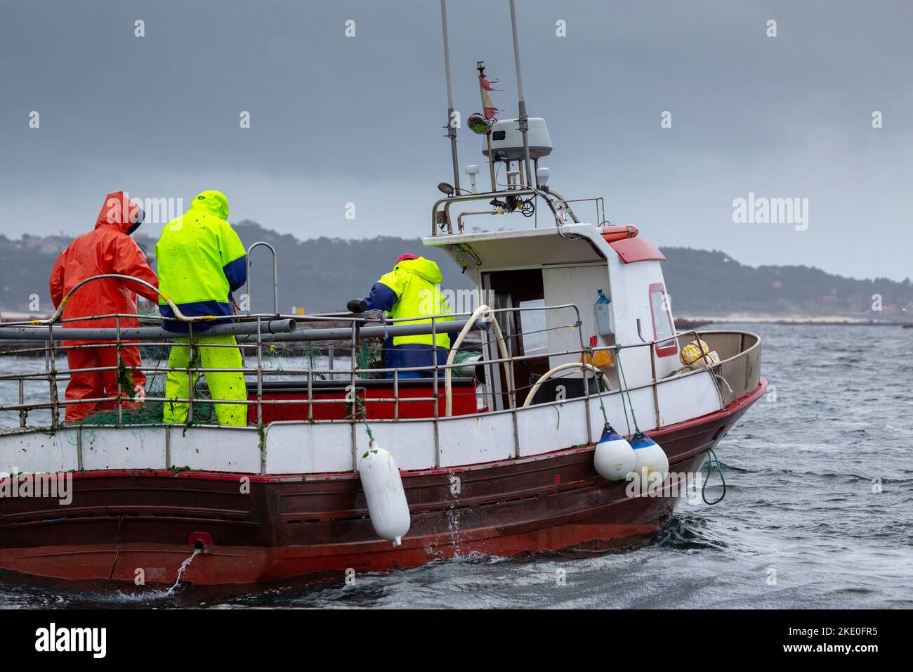 Inshore fishing sailors fish in their traditional wooden boat in the ...