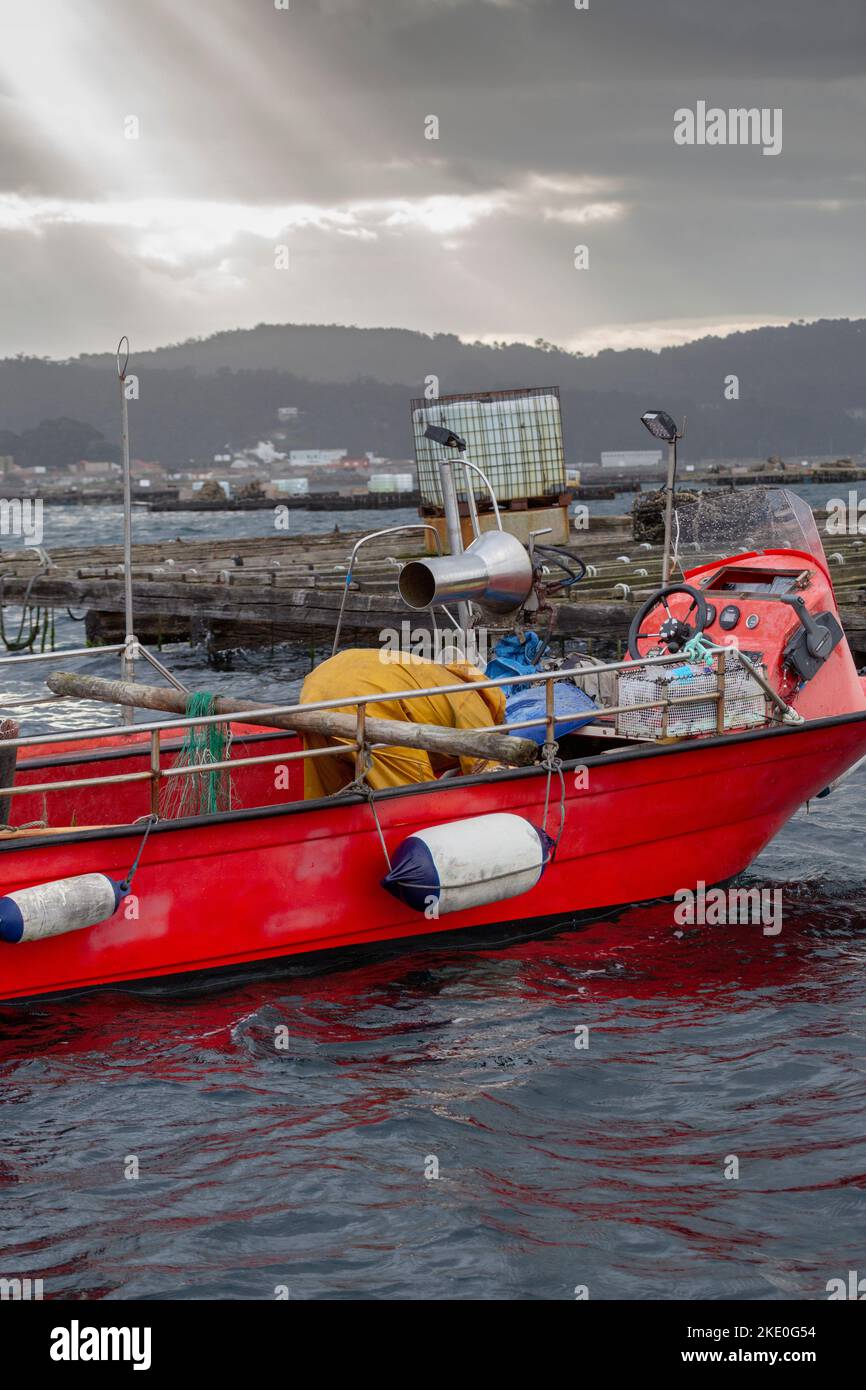 Inshore fishing sailors fish in their traditional wooden boat next to a ...
