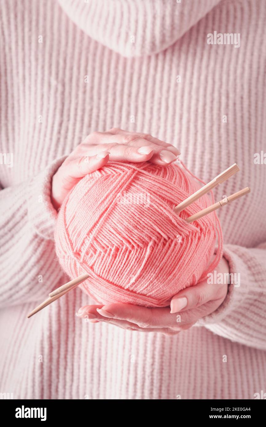 Female hands holding colorful pink wool yarns and wooden knitting ...