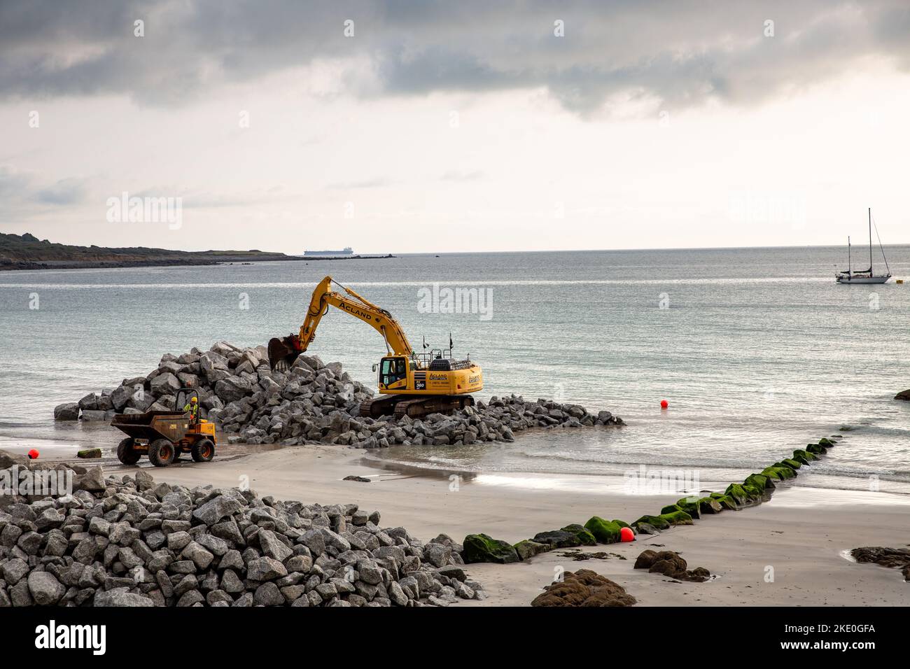 Construction workers using heavy plant machinery to move quarry stone ...