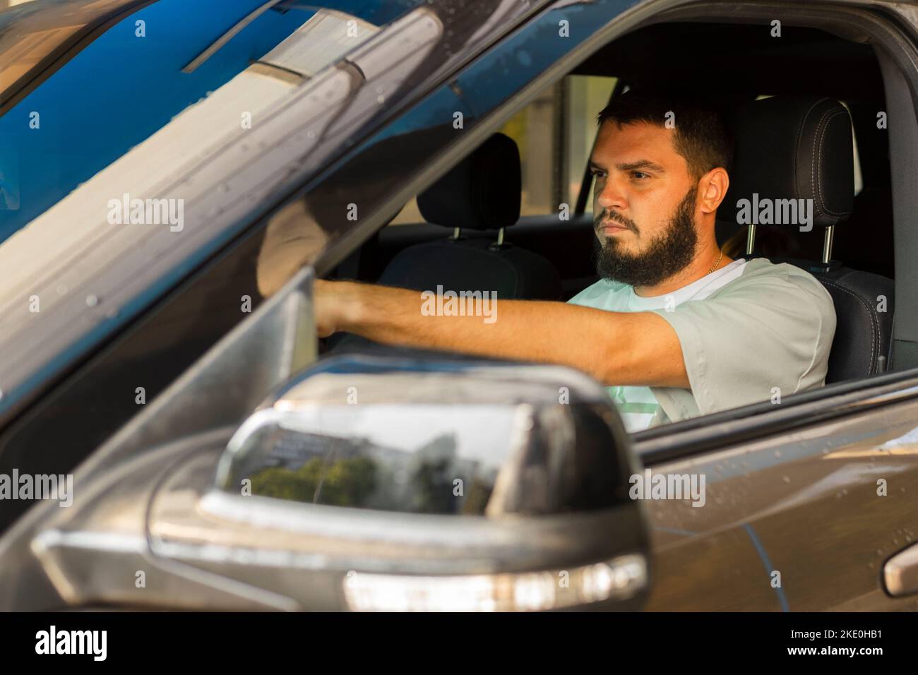 Happy young driver behind the wheel inside new car. Lifestyle scene in ...