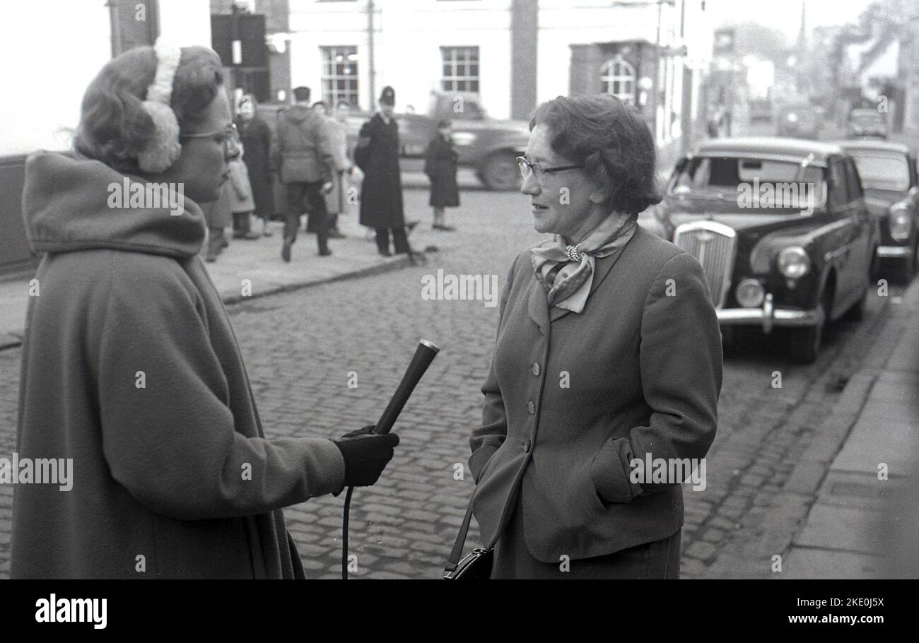 1950s, historical, female reporter with microphone in hand, standing ...