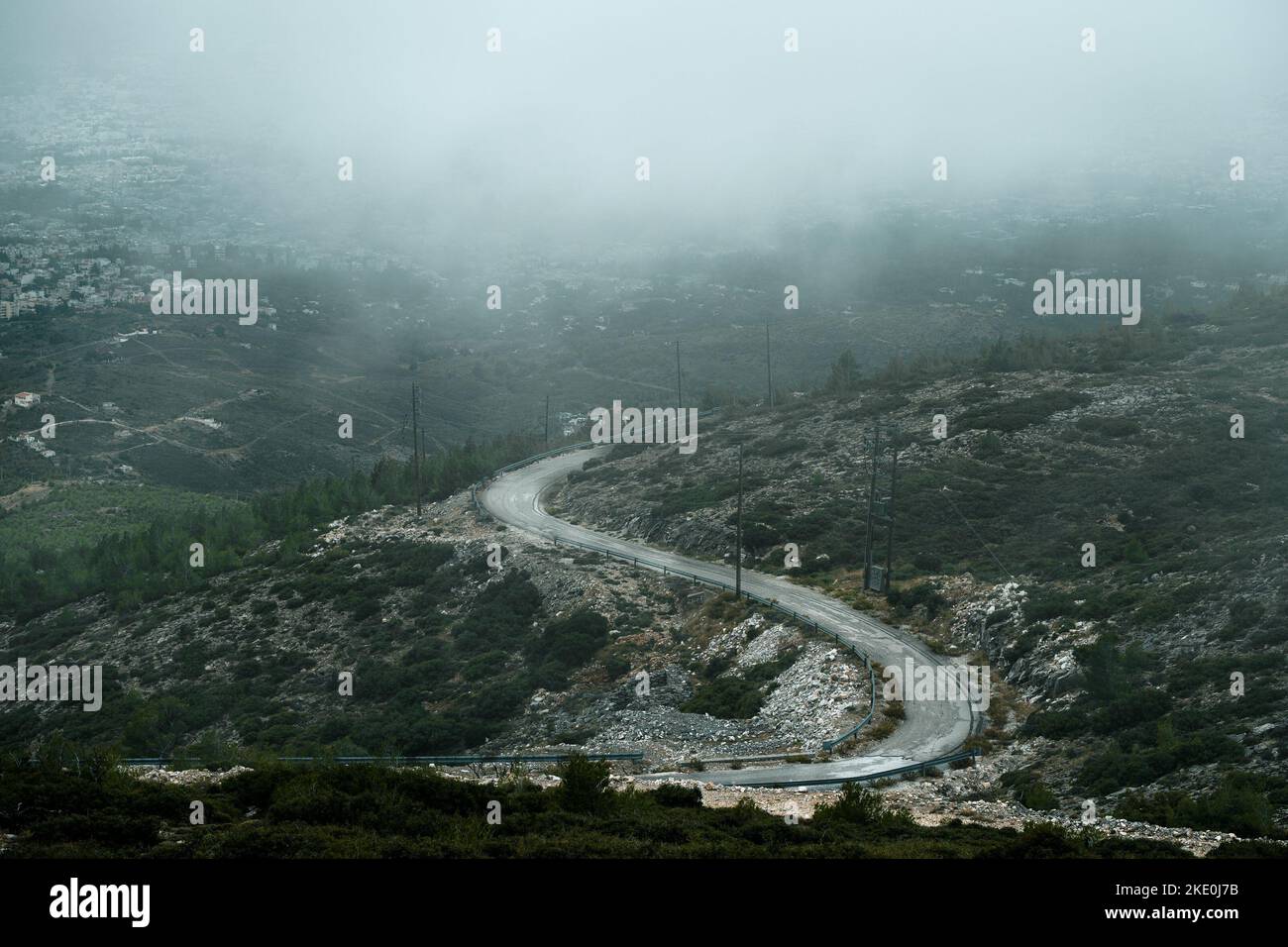 A beautiful shot of an empty road in the mountains in the foggy weather ...