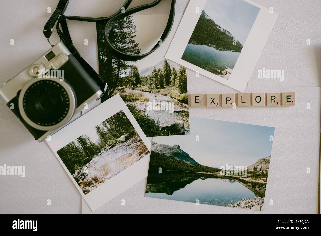 A top view of an Instant camera and photo prints of nature and ...