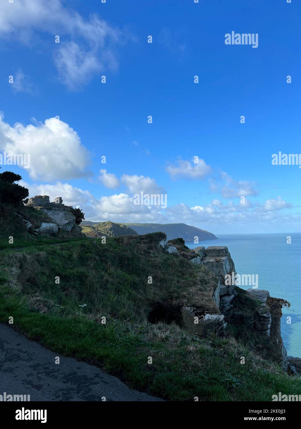 The vertical view of the waterside cliffs under the blue sky in ...
