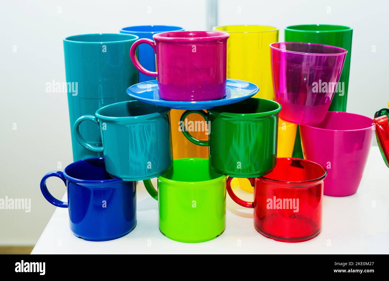 Colorful plastic mugs made of eco-friendly materials on a white ...