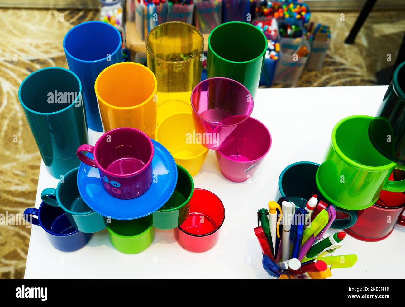 Colorful plastic mugs made of eco-friendly materials on a white ...