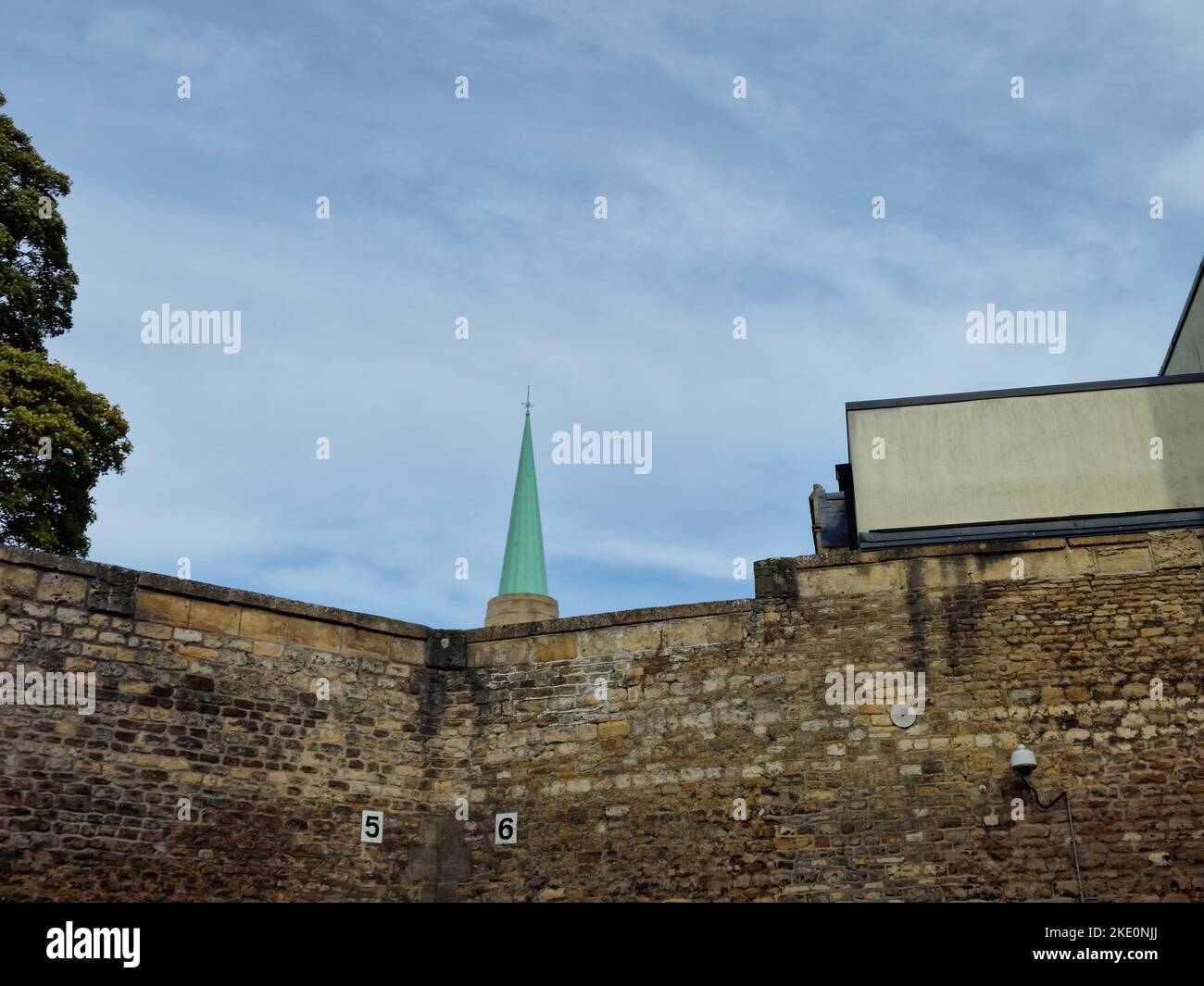 The green tower behind a stone wall. Oxford, England, UK Stock Photo ...