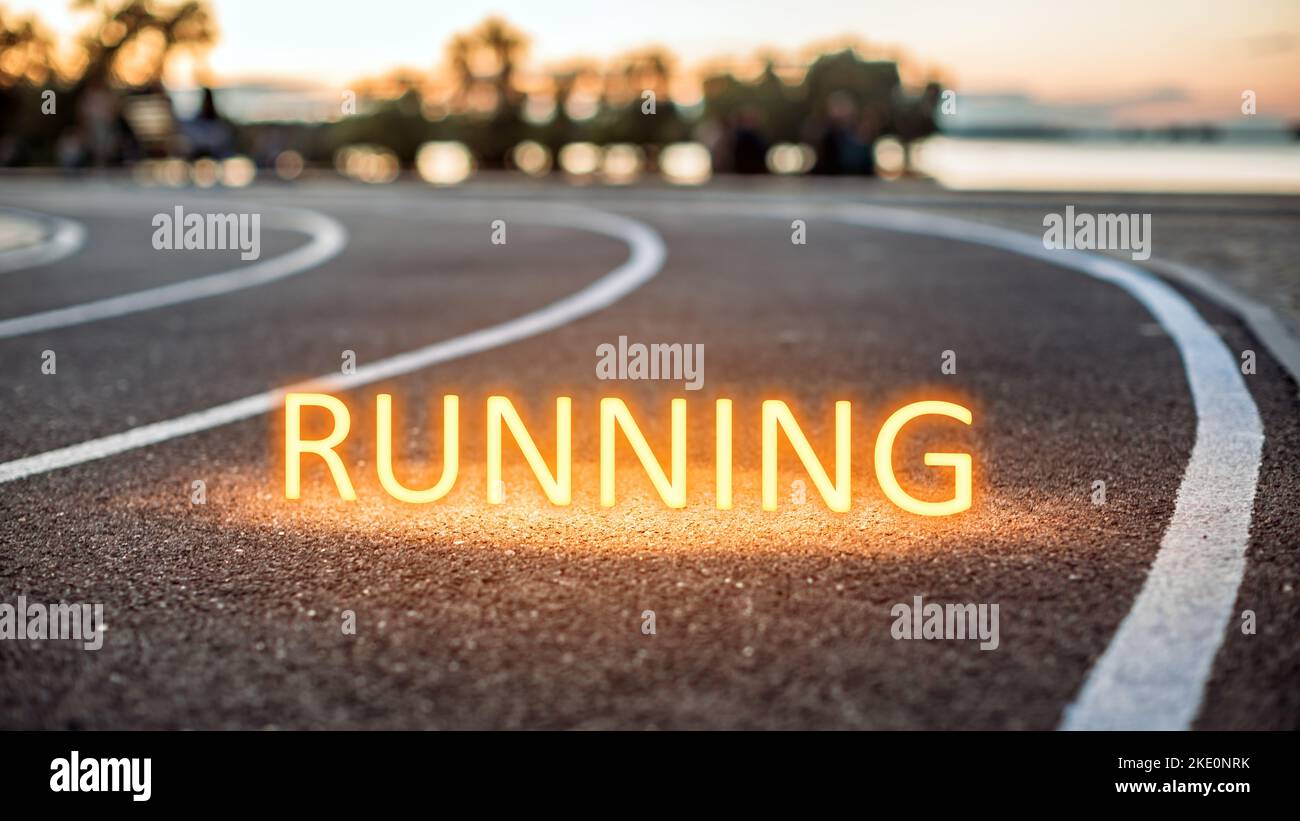 The word running on an asphalt running track in a park near a lake ...