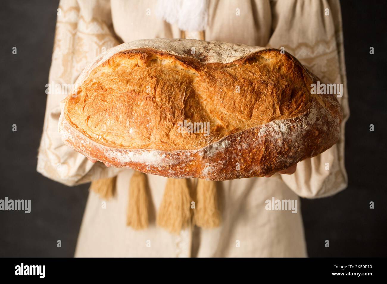 A Ukrainian woman in national dress holds a huge loaf of bread in her ...