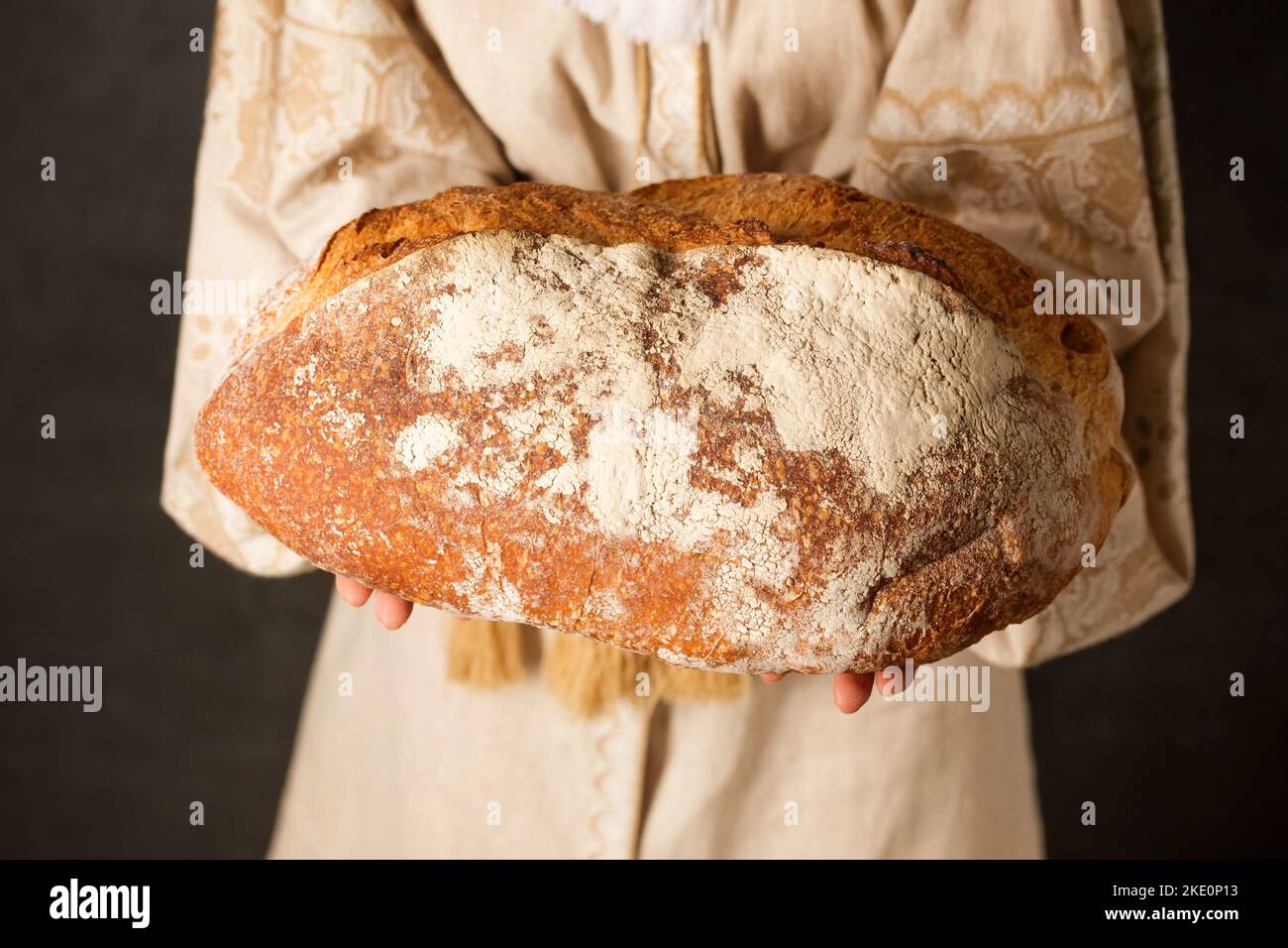 A Ukrainian woman in national dress holds a huge loaf of bread in her ...