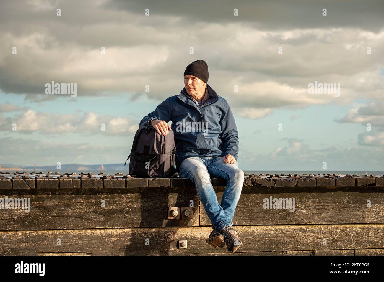 Guy with a backpack sitting resting enjoying the view after walking ...