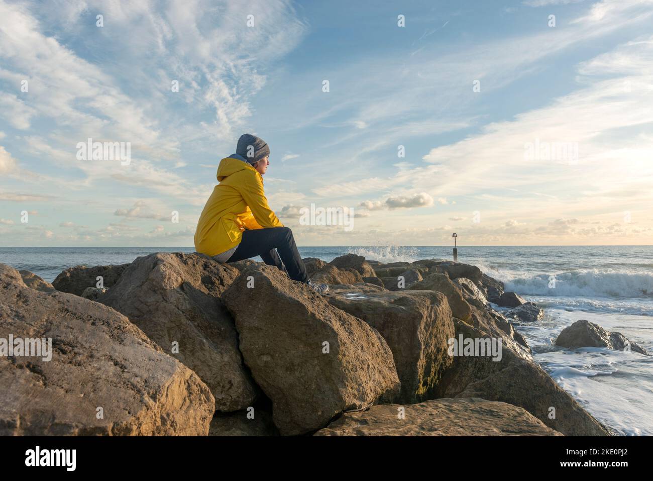 Woman sitting on rocks ocean hi-res stock photography and images - Alamy