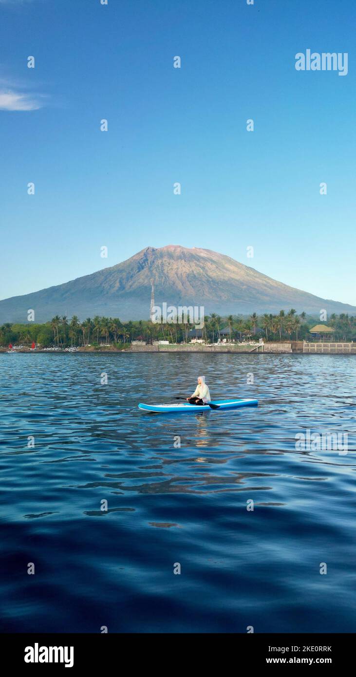 An aerial view of a person in a kayak floating on the water near the ...