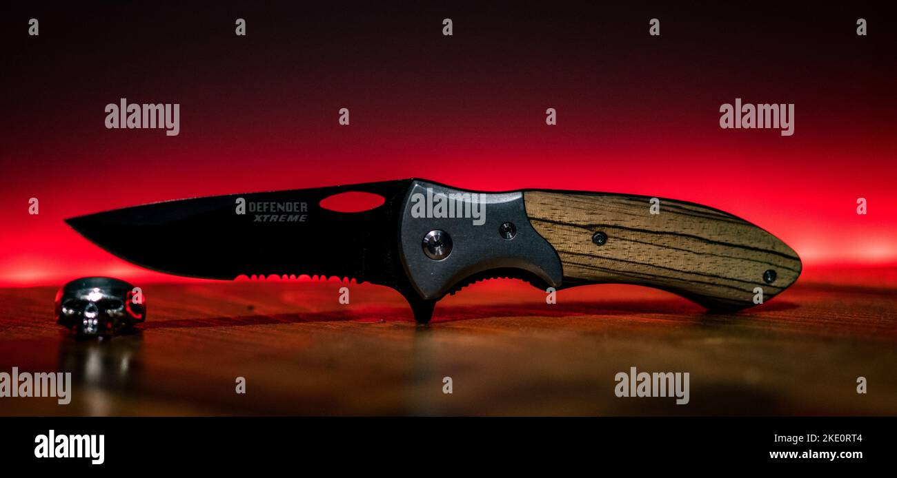 A shot of an extreme Defender branded knife with black blade and a ...