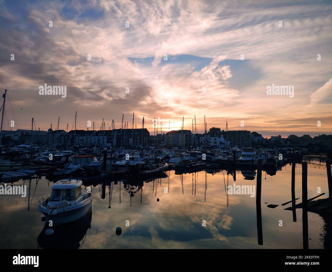 The bright cloudy sunset sky over the group of boats at the harbor ...