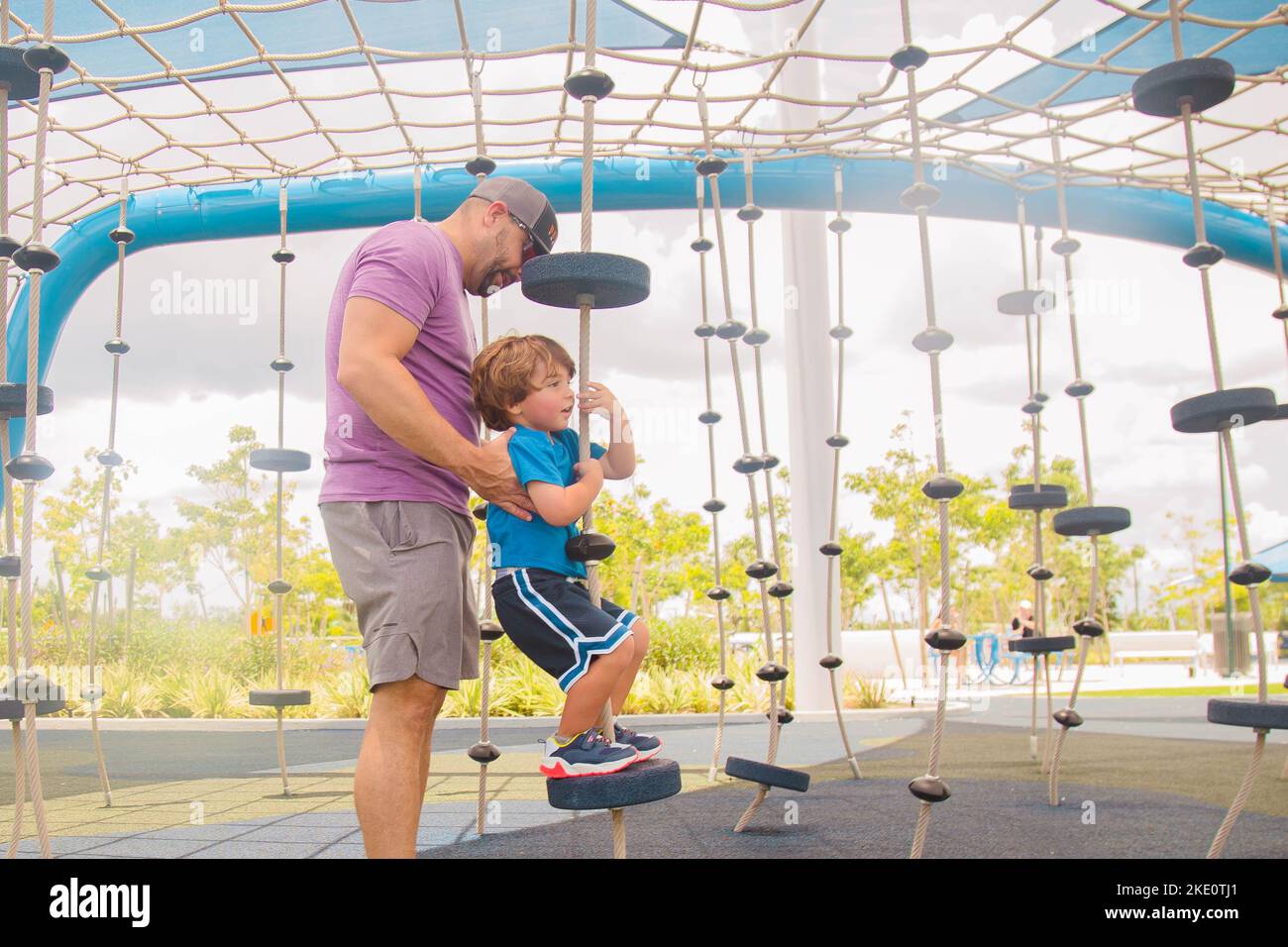 A cute little Caucasian boy playing on the playground with his father ...