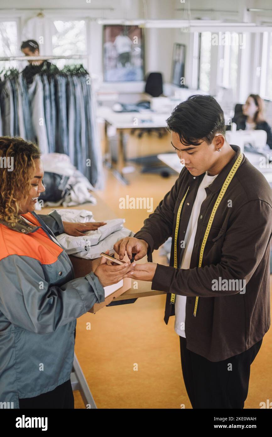 High angle view of male fashion designer doing digital signature while ...