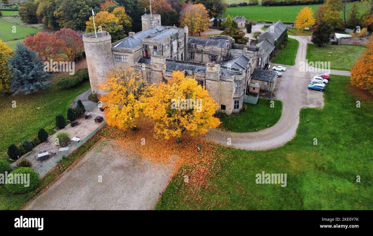 An aerial view of Walworth Castle with colorful autumn trees and parked ...