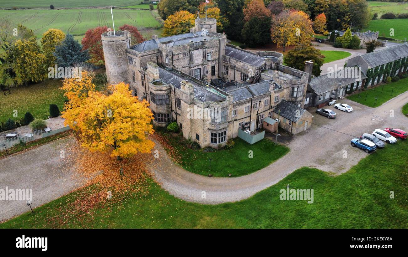 An aerial view of Walworth Castle with colorful autumn trees and parked ...