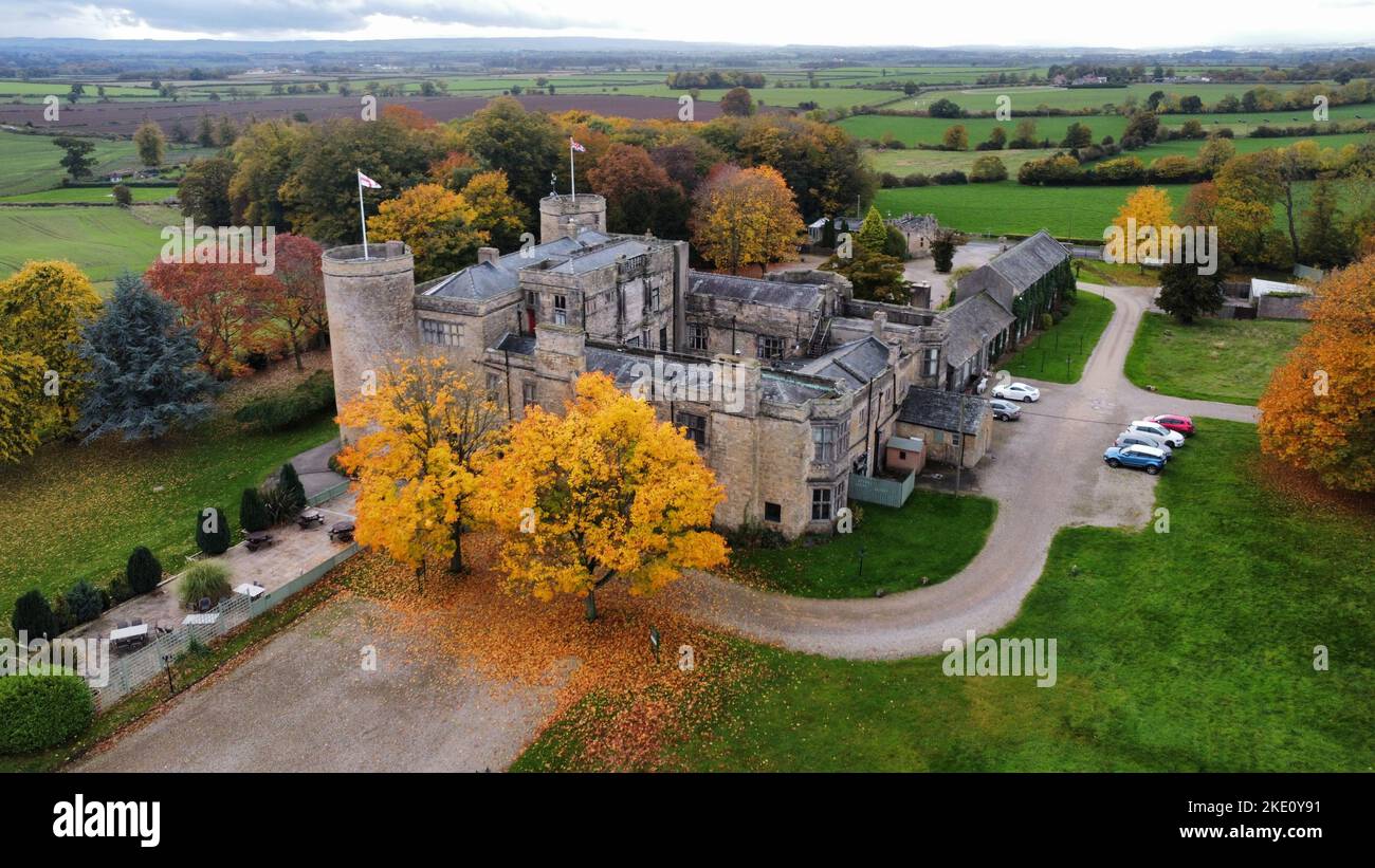 An aerial view of Walworth Castle with colorful autumn trees and parked ...
