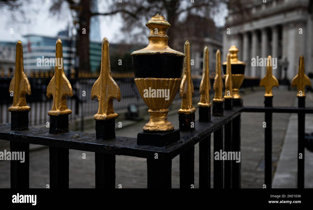 A closeup of the black metal railing with golden tips on the blurry ...