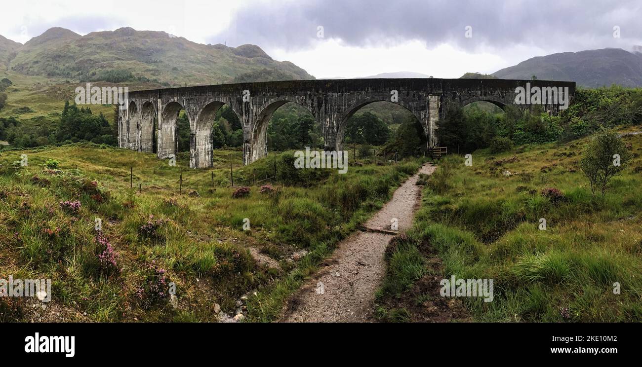 An old ruin arch bridge surrounded by green grasses Stock Photo - Alamy