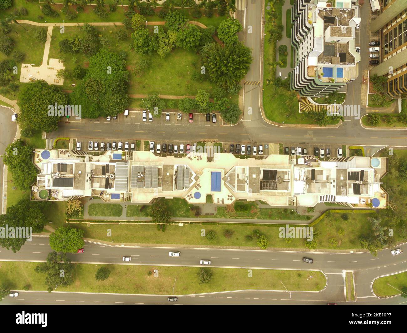 A top view of a modern building with parking and park around Stock ...
