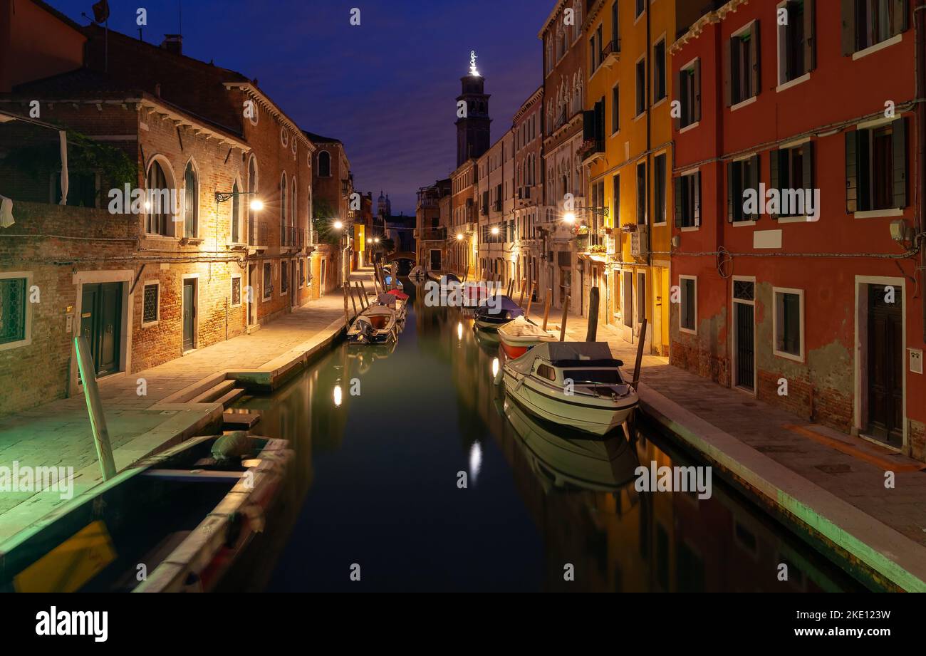 Facades of old traditional medieval houses along the canal at sunrise ...