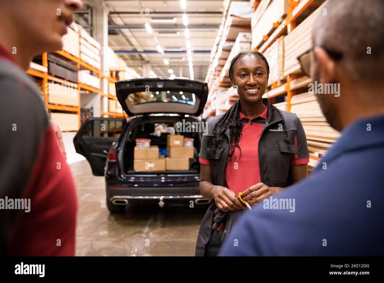 Smiling female sales staff talking with customer in warehouse Stock ...