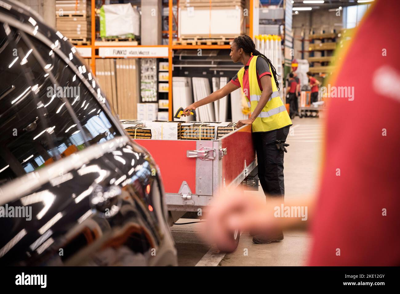 Side view of female sales staff scanning supplies through bar code ...