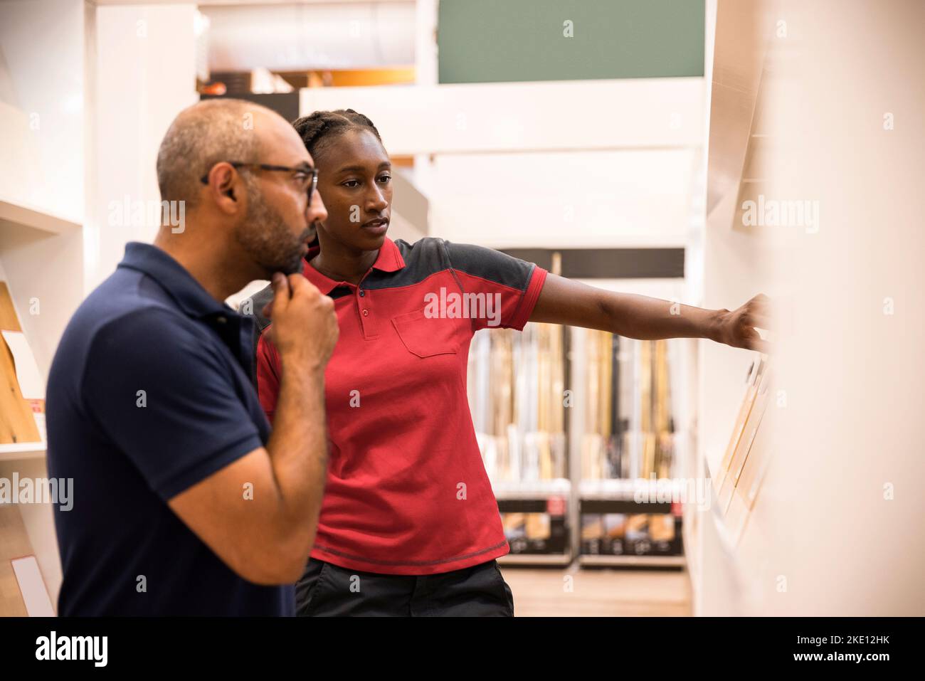 Side view of customer with hand on chin selecting laminated boards ...