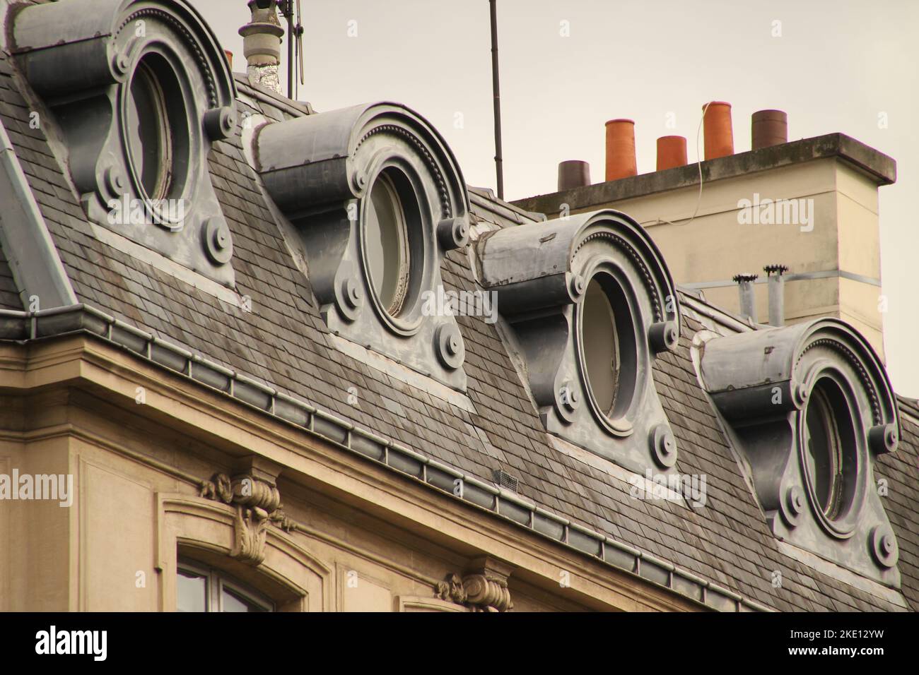 The facade of a beige building with round rooftop windows in downtown ...
