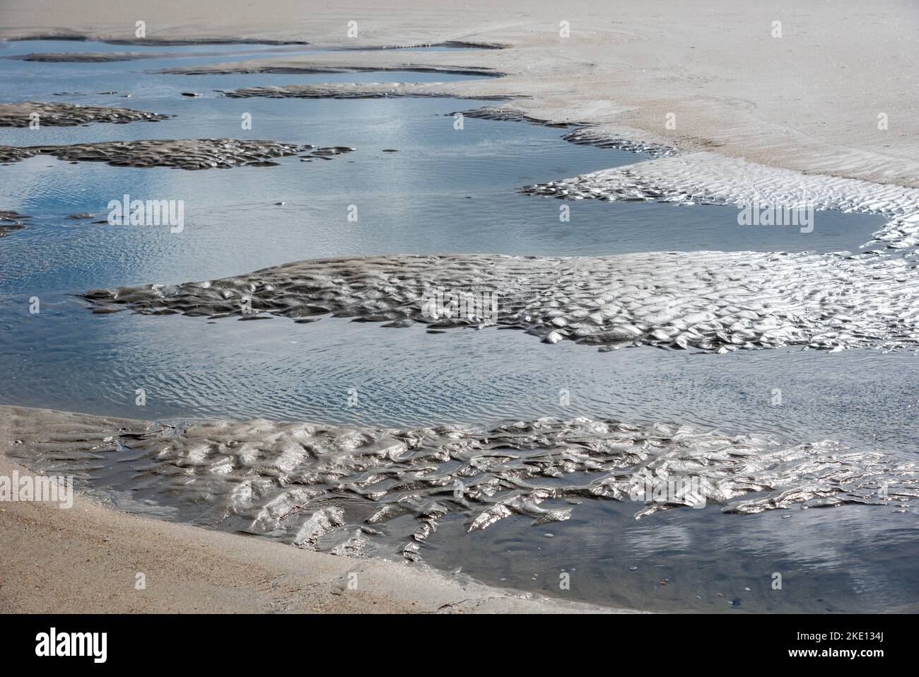 A shot of puddles left behind by a falling tide on a beach at Waipu ...