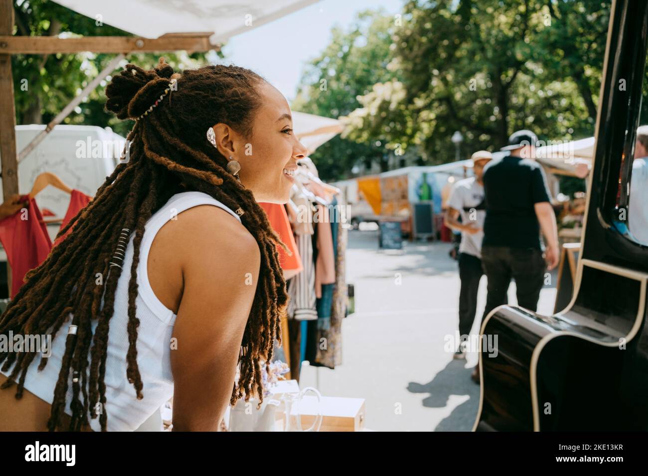 Side view of female owner with dreadlocks in stall at flea market Stock ...