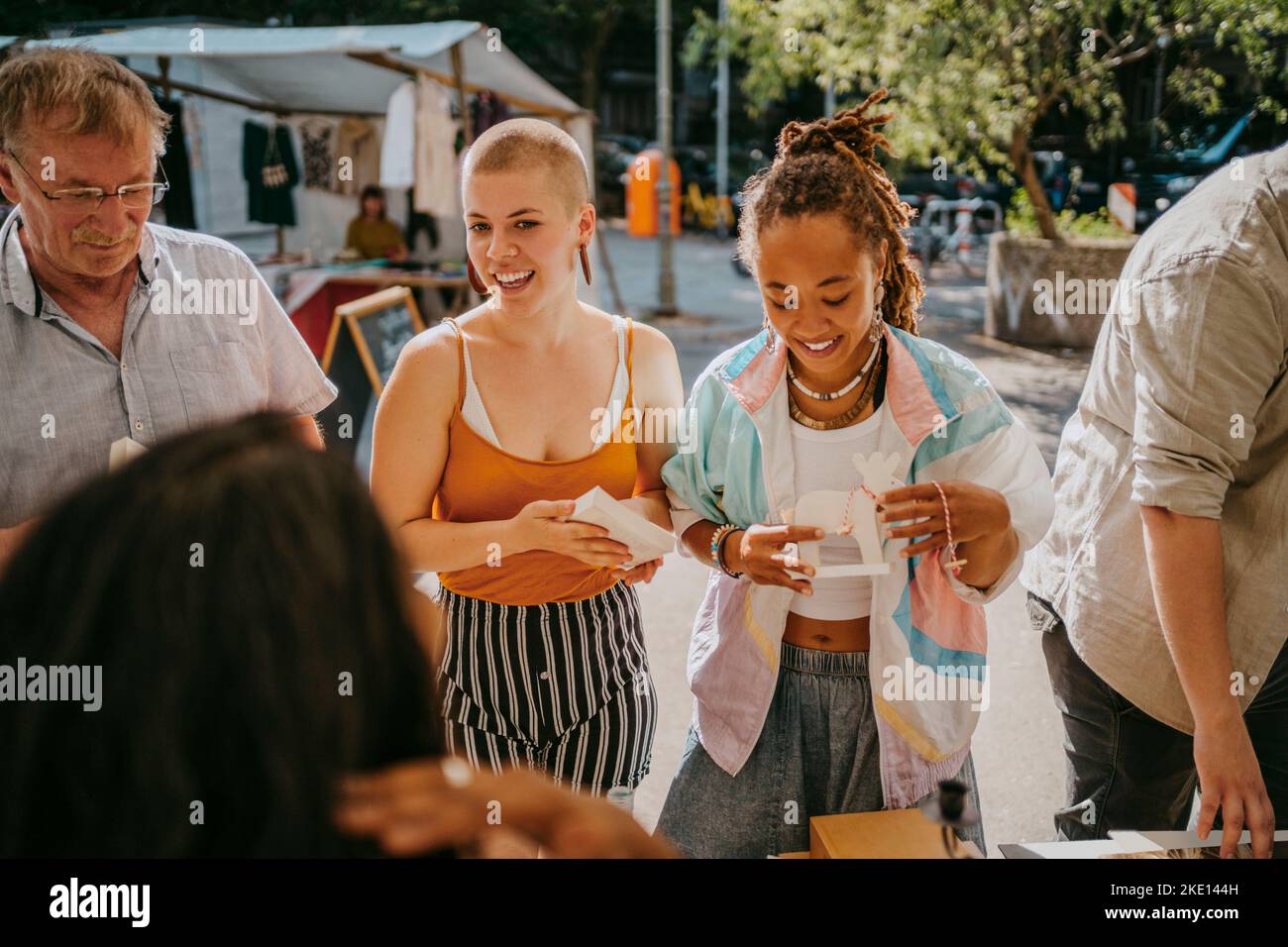Male and female customers bargaining with merchant while shopping at ...