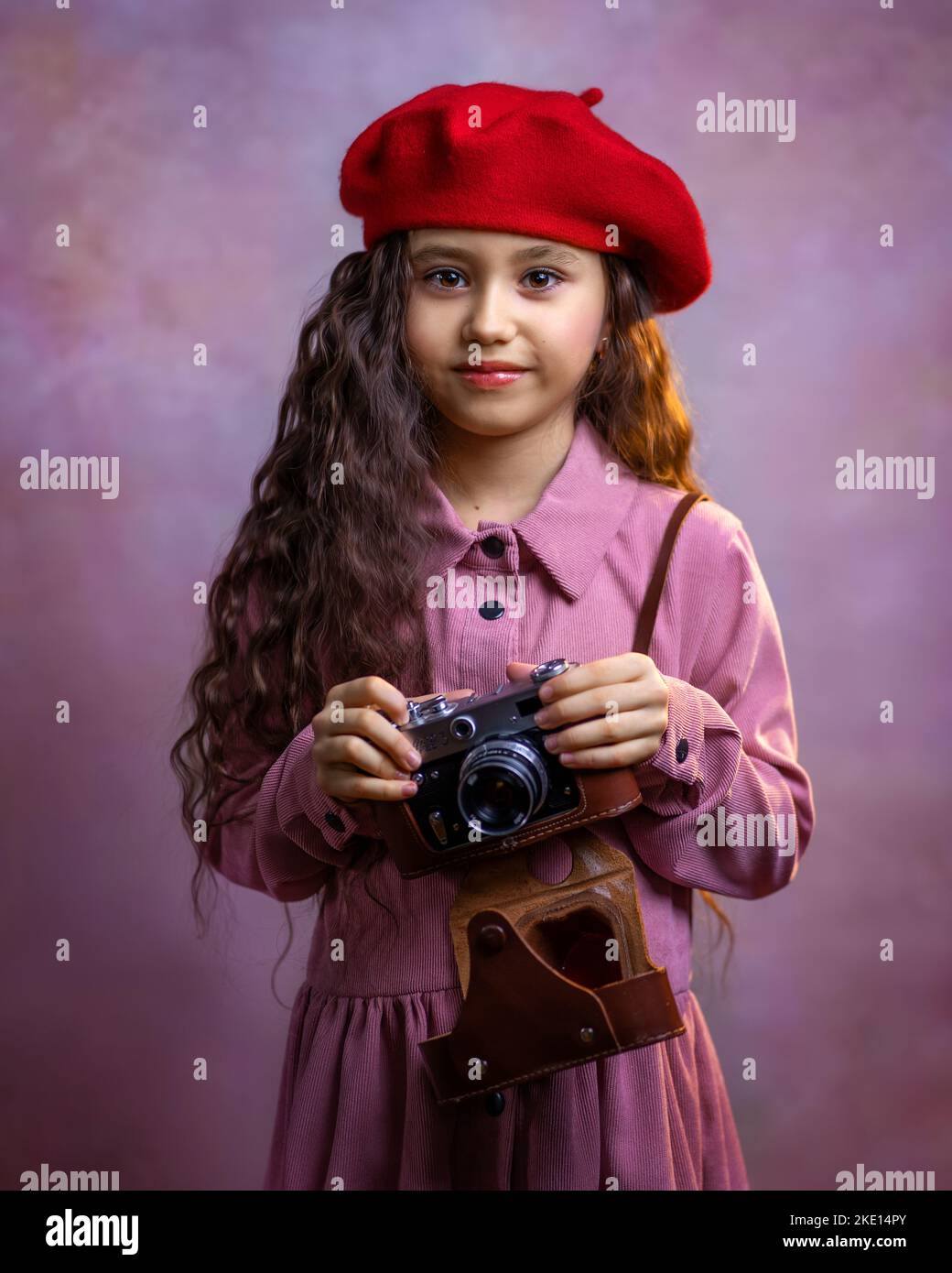 girl in a red beret with a camera smiling Stock Photo - Alamy