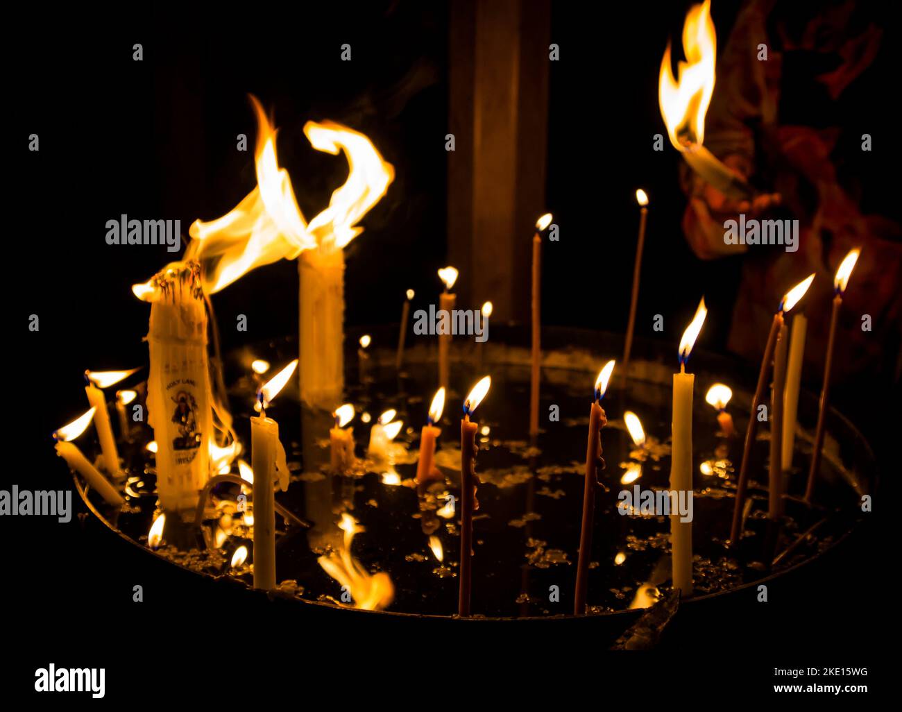 The dramatic lit candles in the church on the black background Stock ...