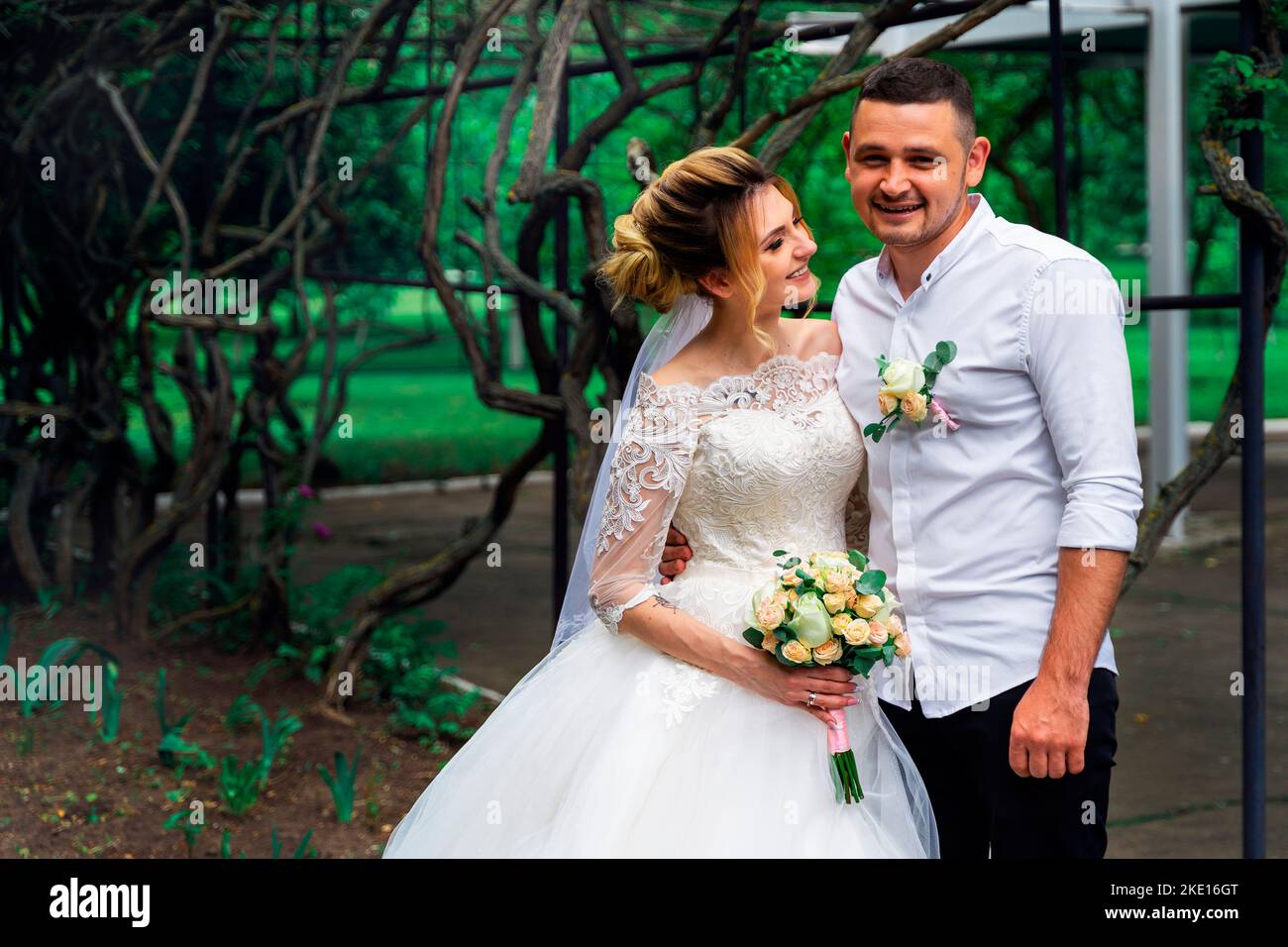 The bride looks at and smiles at him Stock Photo - Alamy