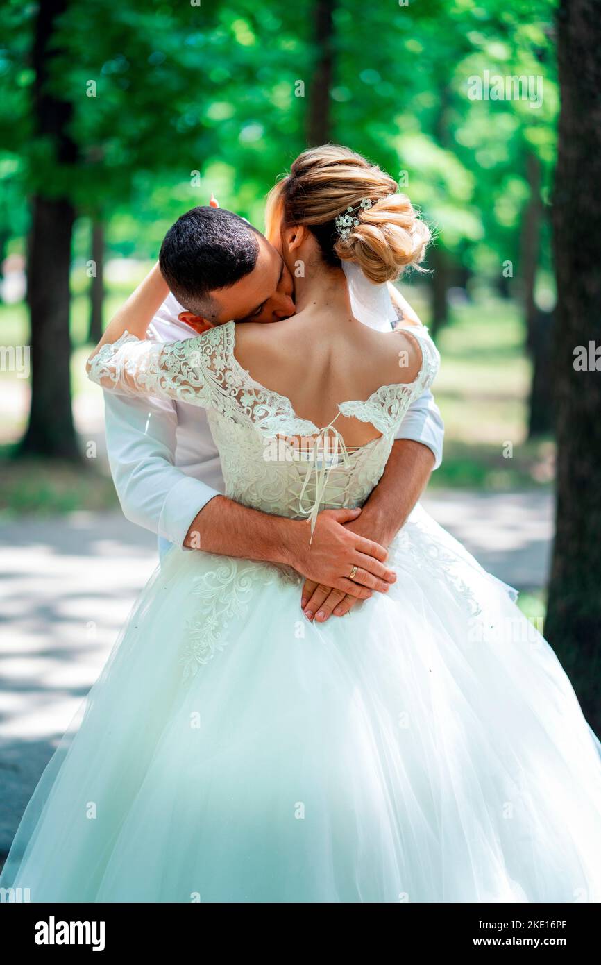 The groom kisses the bride on the neck Stock Photo - Alamy