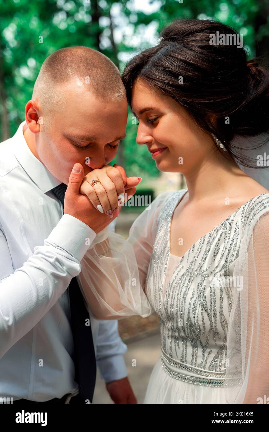 The groom kisses the hands of his wife Stock Photo - Alamy