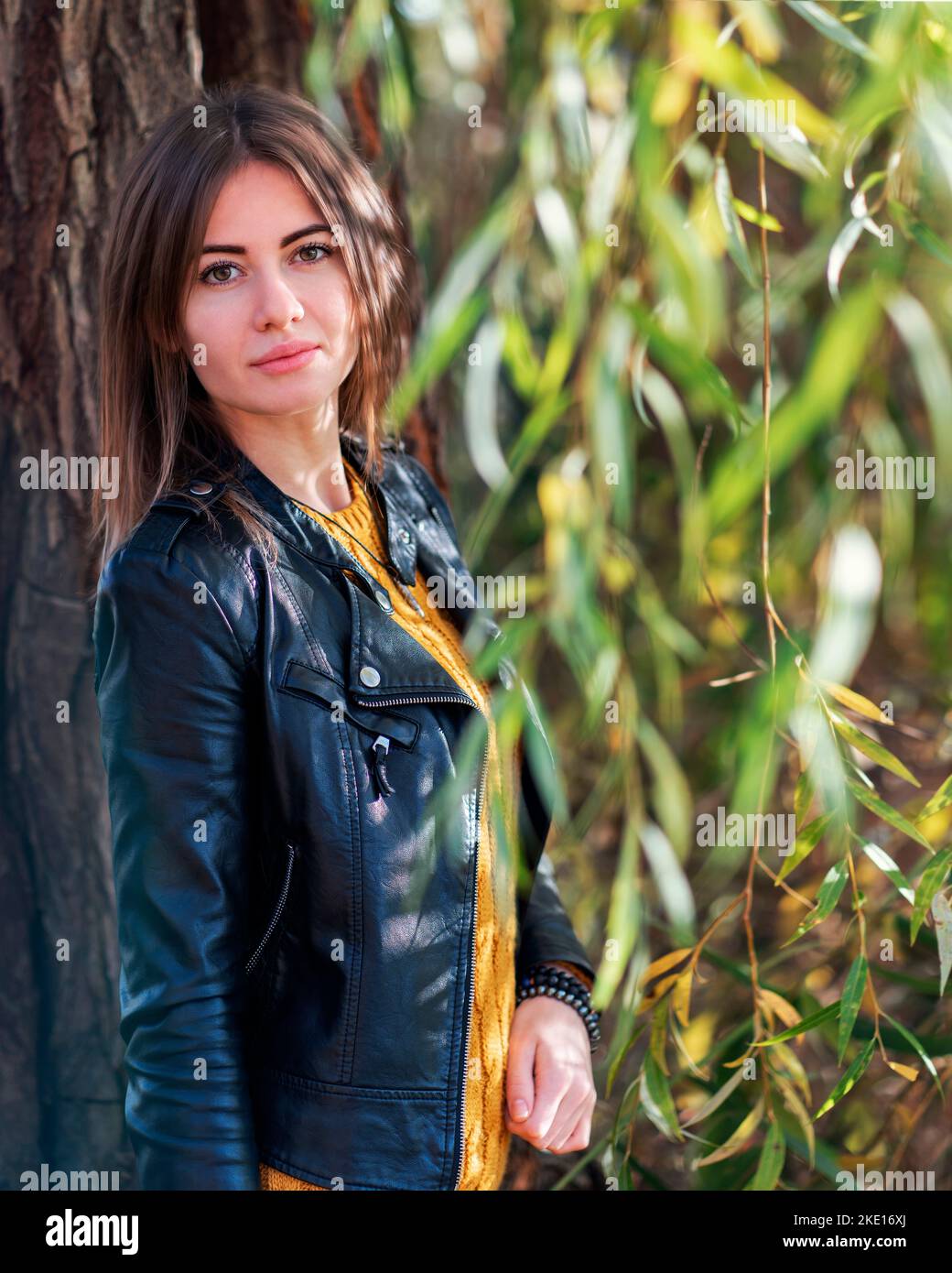 Beautiful girl in the leaves of a tree Stock Photo - Alamy
